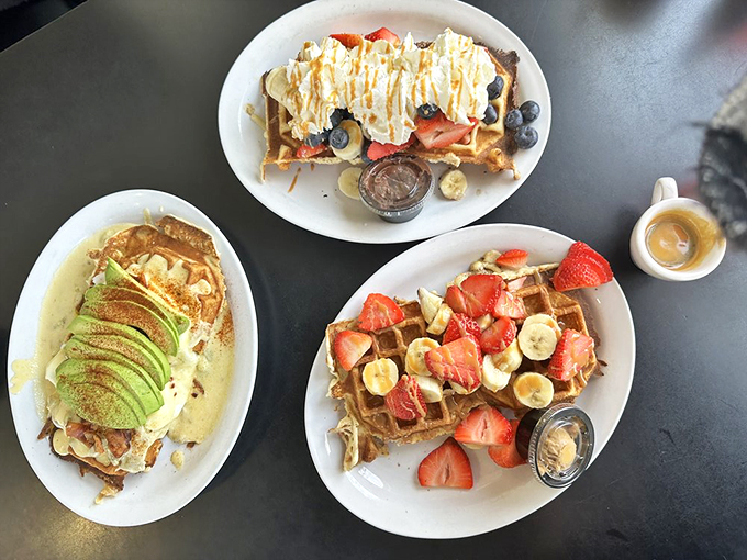 The holy trinity of breakfast: avocado toast's sophisticated cousin, fruit-laden sweetness, and classic berries with cream—a brunch table that speaks three languages fluently.