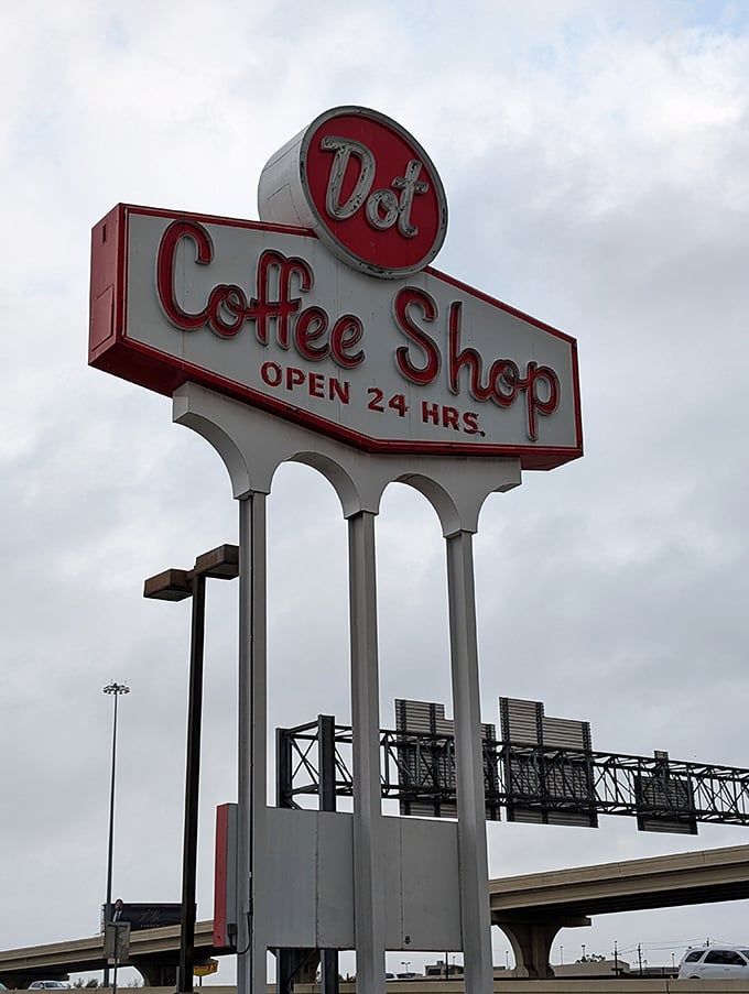 Dot Coffee Shop's iconic sign towers above the highway – a retro beacon promising "OPEN 24 HRS" of breakfast bliss.