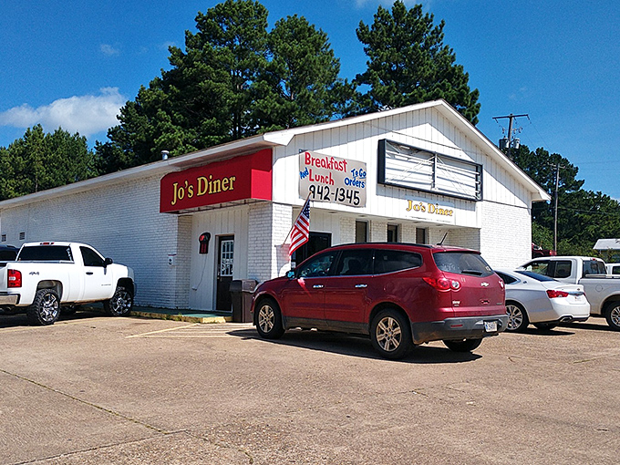 Jo's Diner's classic white building with red trim promises honest cooking without pretense—just like grandma would approve.