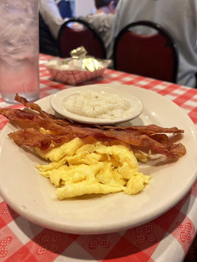 Breakfast fundamentals done right: eggs scrambled to fluffy perfection, bacon with that ideal curve of crispness, and grits so creamy they could make a Northerner convert.