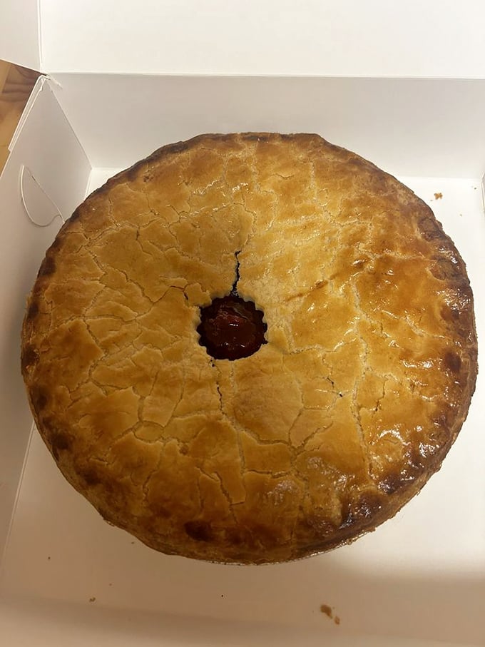 This cherry pie isn't just dessert, it's architecture—a golden dome of flaky pastry protecting its ruby treasure like Fort Knox, but much more delicious.