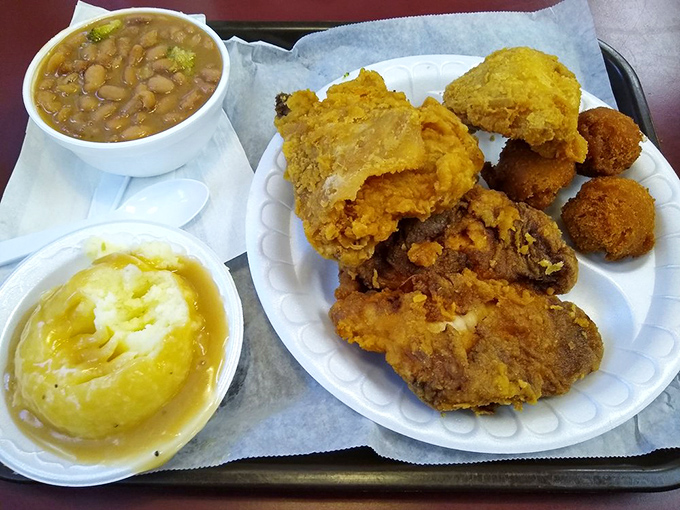 A mountain of golden-fried chicken, beans, and those famous potatoes—proof that the best things in life don't need fancy packaging.