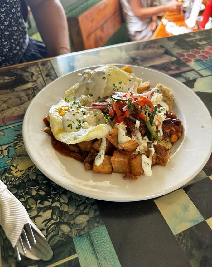 Breakfast with altitude&mdash;eggs perched majestically atop a mountain of potatoes, vegetables, and sauces that dance together in perfect harmony.