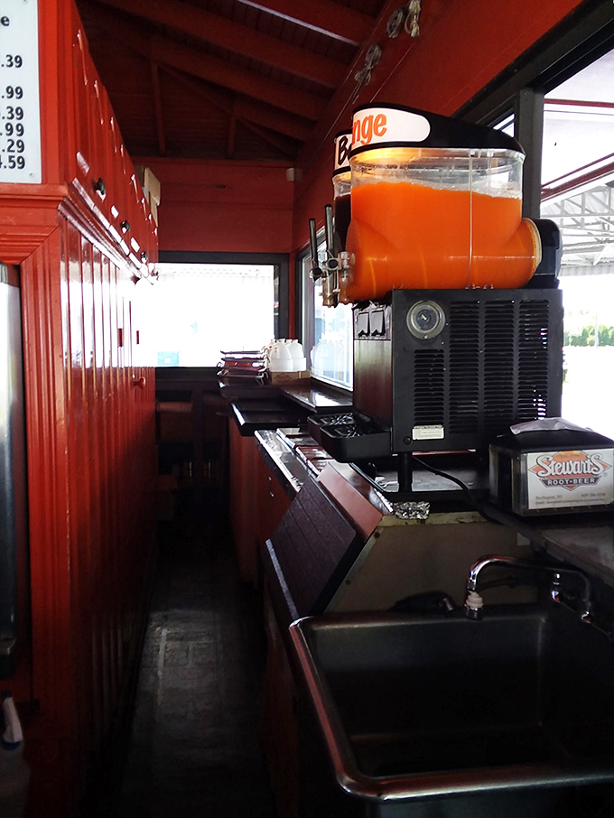 Behind the scenes magic where orange crush meets culinary craft. The slushie machine stands sentinel, ready to dispense frozen happiness to parched New Jerseyans.