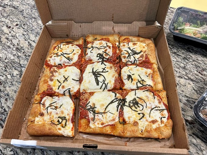 Square pizza that doesn't cut corners on flavor. That basil isn't just garnish—it's making a bold declaration of freshness.