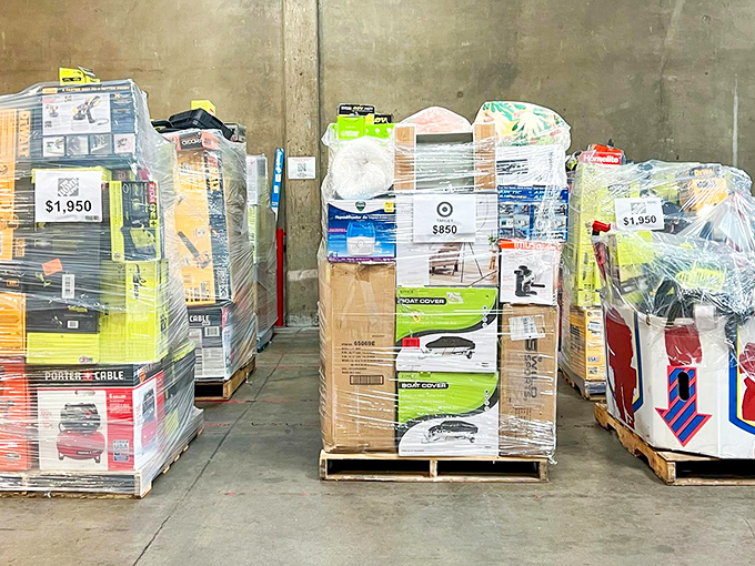 Pallets wrapped like retail Christmas presents, each labeled with their total value&mdash;a visual reminder of just how deep the discounts go.