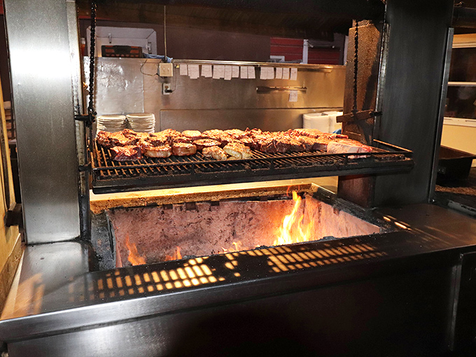 The heart of the operation: red oak flames licking at prime cuts. This isn't cooking&mdash;it's a primal ritual that transforms mere meat into legend.