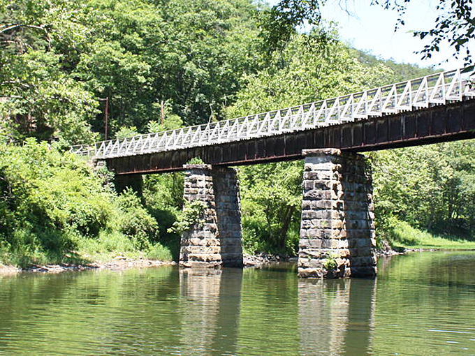 This bridge doesn't just connect two riverbanks&mdash;it links present to past. Stone pillars and wooden planks create a crossing that's both practical and poetic.