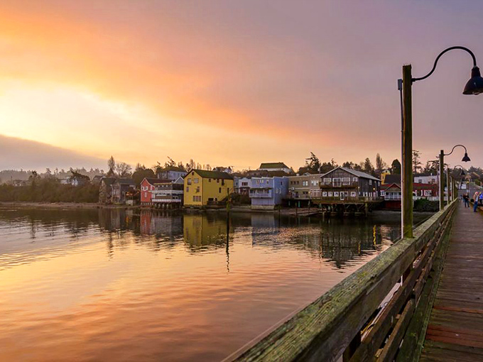 Sunset stroll along the waterfront promenade, where the town's colorful buildings create a reflection that doubles the visual delight.