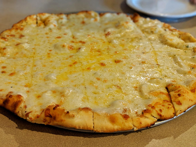 A cheese pizza that proves simplicity is the ultimate sophistication. That golden crust is the frame for a masterpiece of melted perfection.