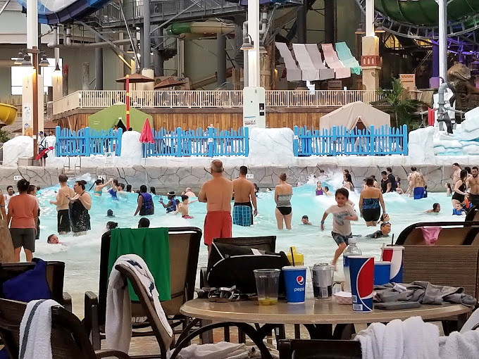 Every table becomes premium real estate during peak hours, serving as command central for towels, snacks, and between-slide hydration stations.