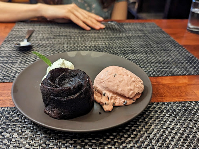 A chocolate dessert so rich it probably has its own investment portfolio, served with ice cream that melts with perfect timing.