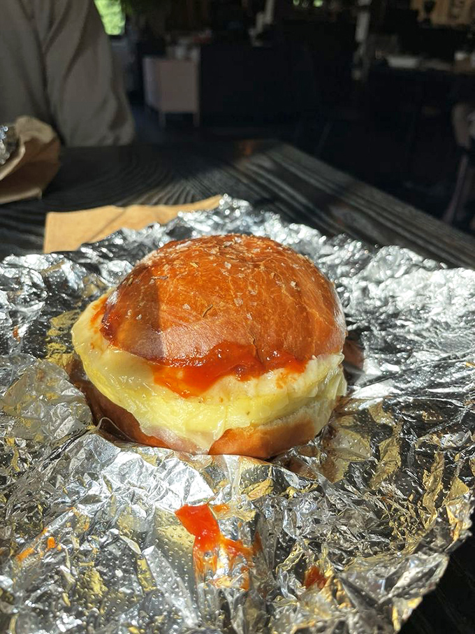 Breakfast sandwich wrapped like a present. That melty cheese and glistening roll are making promises they absolutely intend to keep.