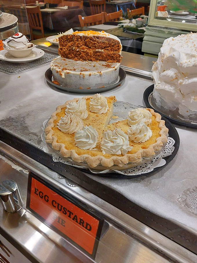 Egg custard pie topped with whipped cream dollops like clouds floating over a sunset-colored horizon. Dessert that demands you save room.