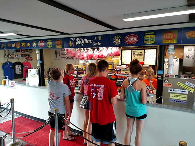 The sacred queue for concessions, where decisions between candy and popcorn reach existential importance under the "Skyline Cafe" banner.