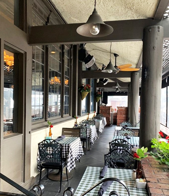 Outdoor dining with checkered tablecloths and hanging plants&mdash;it's like someone bottled the essence of "pleasant afternoon" and made it a space.