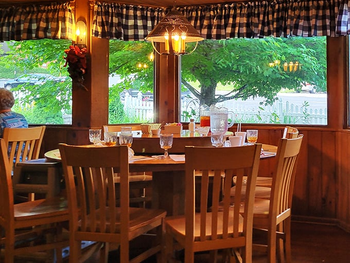 Window-side tables bathe diners in natural light while gingham curtains frame the view like a living postcard of small-town America.