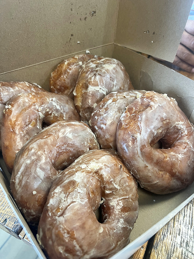 These glazed donuts huddle together in their box like old friends, each one promising a perfect sweet-to-dough ratio.