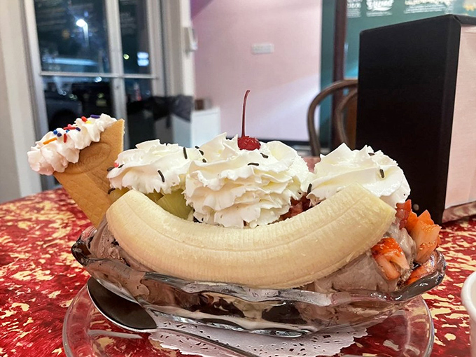 This banana split isn't just dessert, it's architecture. The whipped cream towers and wafer buttresses would make Frank Gehry jealous.