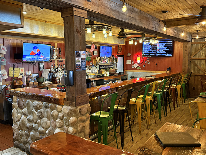 Colorful metal stools punctuate the rustic stone and wood bar&mdash;a playful touch in a space that perfectly balances rugged charm with inviting comfort.
