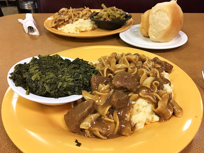 Beef tips and noodles lounging on a bed of mashed potatoes with greens on the side. Comfort food architecture at its finest.