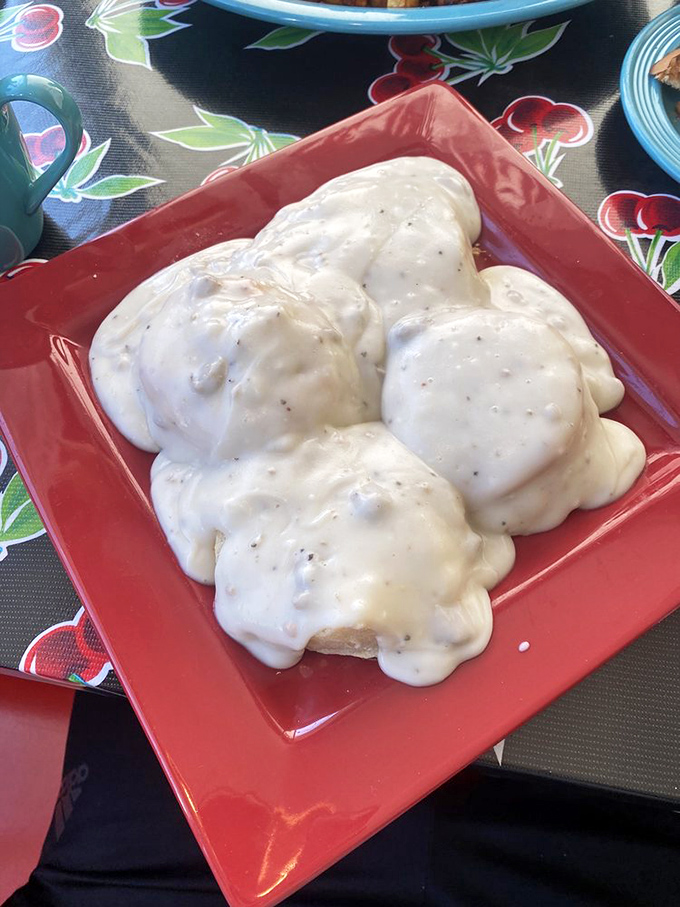 Biscuits and gravy that would make your Southern grandmother both proud and jealous. That red plate isn't just serving food&mdash;it's presenting an American masterpiece.