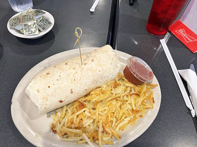 A breakfast burrito large enough to have its own zip code, accompanied by golden hash browns. Morning fuel for serious appetites.