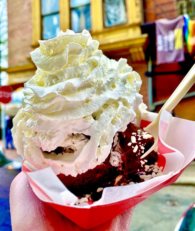 This isn't just dessert, it's architecture&mdash;whipped cream peaks towering over red velvet valleys in a paper boat of pure bliss.