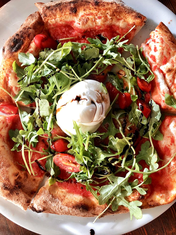 Another angle of pizza perfection: the arugula adds peppery brightness while the burrata center melts like a dairy supernova. Pizza poetry.