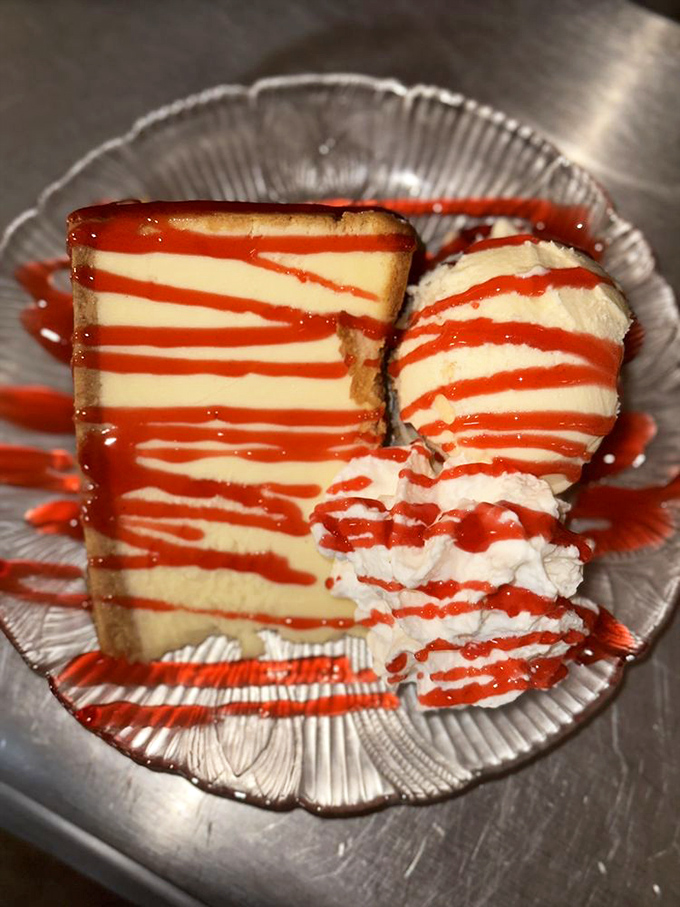 A slice of cheesecake with strawberry drizzle that makes dieting tomorrow seem like a reasonable compromise. Worth every caloric penny.