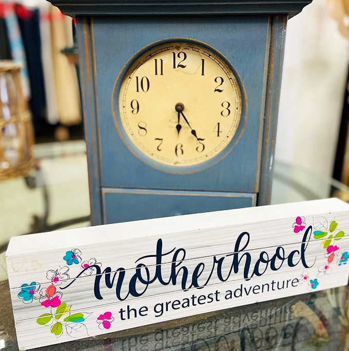 Time stands still for this charming blue clock, positioned above a handcrafted sign celebrating motherhood—two treasures awaiting separate homes.