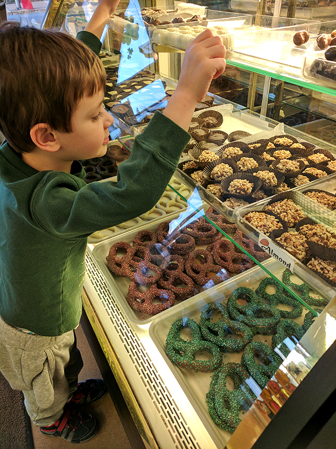 The wide-eyed wonder of childhood meets the artistry of baking as a young customer contemplates the life-changing decision of which pretzel to choose.