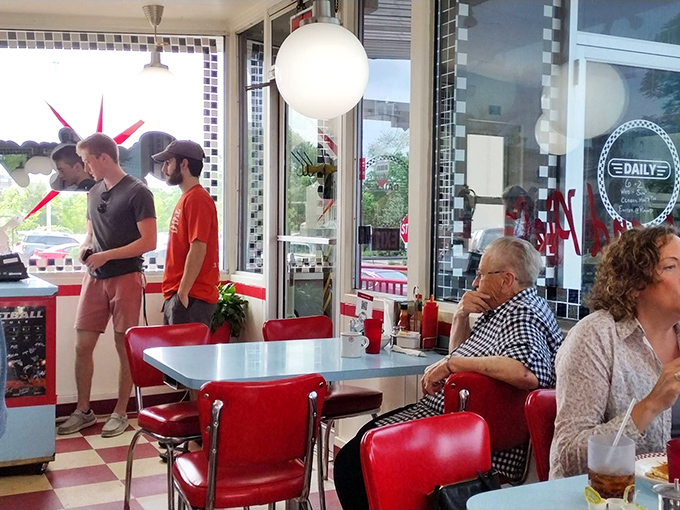 The dining room brings strangers together under globe lights, where conversations flow as freely as the coffee refills.