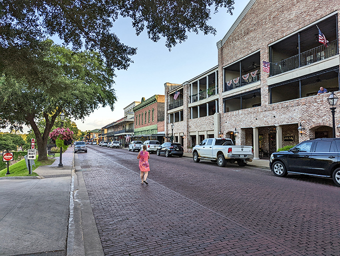 A woman in pink strolls across historic brick streets that have welcomed visitors since before New Orleans was even a twinkle in France's eye.