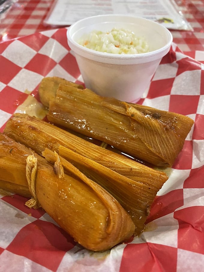 Mississippi Delta tamales wrapped in their corn husk blankets, served with slaw. These little bundles of joy are Southern history you can eat.