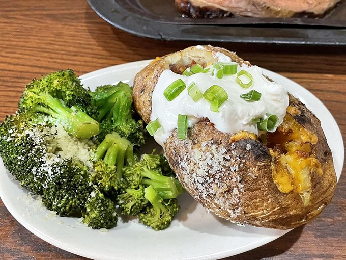 A loaded baked potato that's dressed better than most people at the restaurant, with a side of broccoli playing the role of "token vegetable."