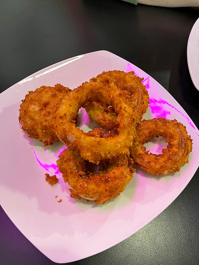 Golden onion rings that crunch like autumn leaves, with a perfect circle that would make my high school geometry teacher proud.