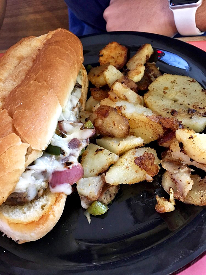 This Philly sandwich isn't just lunch&mdash;it's a beautiful commitment to melted cheese, savory meat, and a pile of home fries that clearly got the memo about proper seasoning.