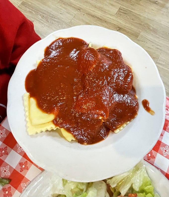Ravioli swimming in that signature sauce isn't just pasta—it's edible poetry served on everyday china instead of parchment.