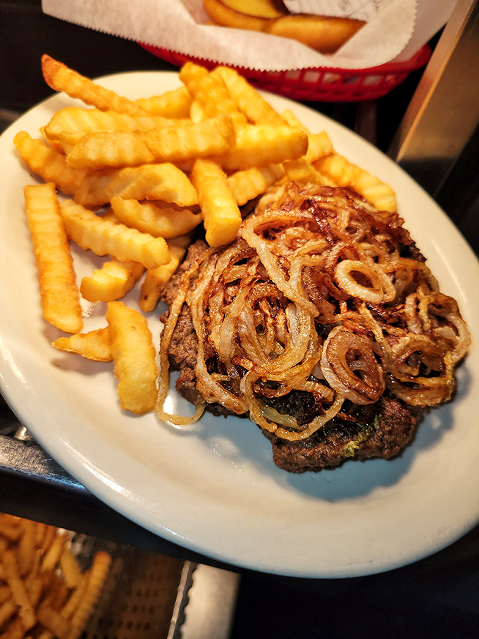 This isn't just a burger with grilled onions&mdash;it's edible poetry on a plate, accompanied by crinkle-cut fries that deserve their own fan club.