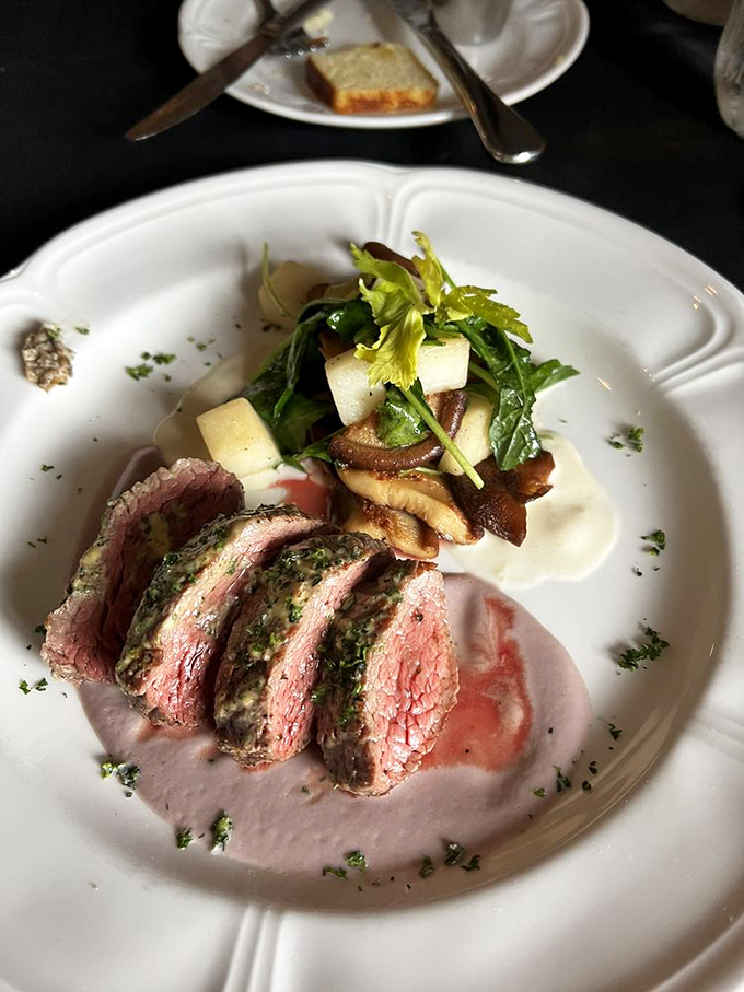 Sliced tenderloin that reveals its perfect pink interior like a magic trick. The accompanying mushrooms and greens provide earthy counterpoints to the rich meat