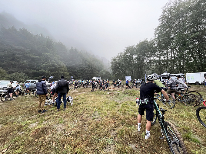 Morning fog embraces a gathering of mountain bikers. The perfect dramatic backdrop for adventures that will become slightly exaggerated dinner stories.