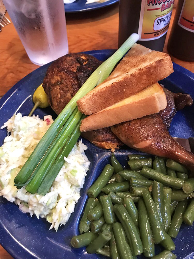 Chicken quarters with the holy trinity of sides: green beans, coleslaw, and Texas toast—a plate that would make any grandma proud.