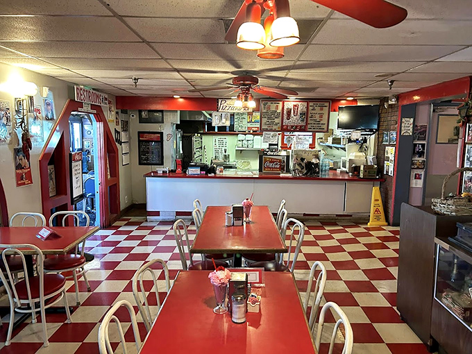 Red tables against checkerboard floors create the perfect backdrop for food that doesn't need Instagram filters to look good.
