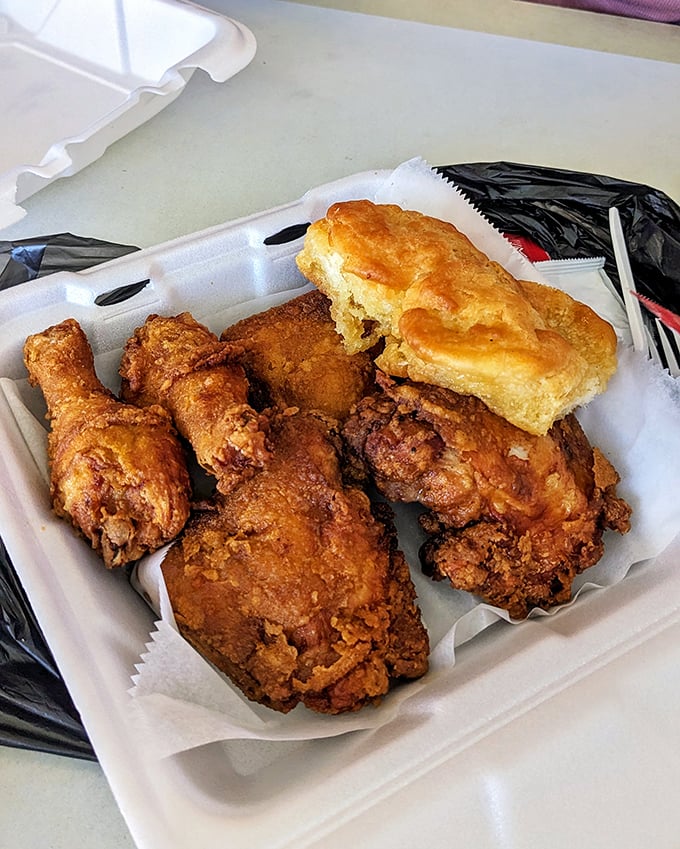 The holy trinity of fried chicken perfection: crispy exterior, juicy interior, and a biscuit that would make your grandmother nod in approval.