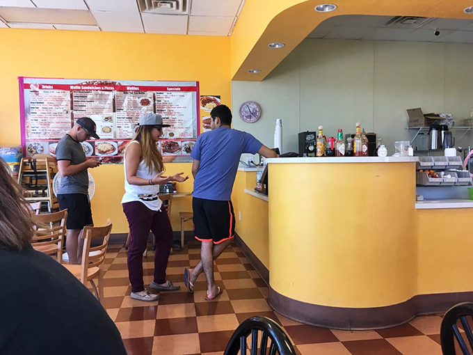 The yellow counter and checkered floor create the perfect backdrop for that morning ritual of ordering, waiting, and anticipating waffle perfection.