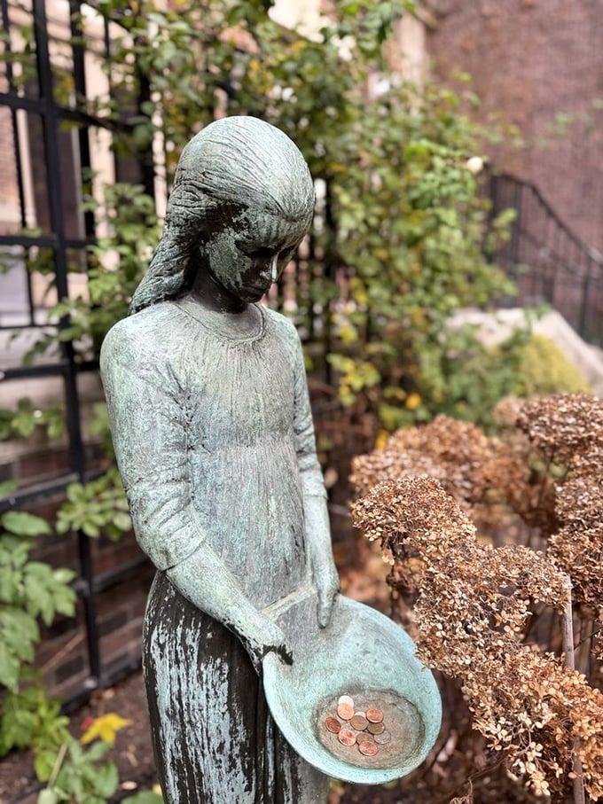 This contemplative garden statue cradles pennies left by visitors&mdash;small offerings to the spirits of medical history and human compassion. 