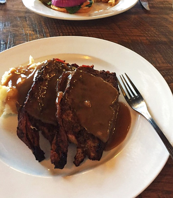 Meatloaf so good it deserves its own Instagram account. That rich gravy cascading down the sides is performing culinary poetry on your plate.