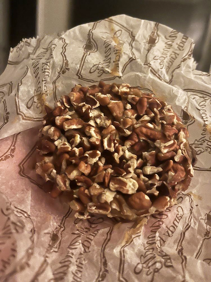 A freshly made pecan praline, still warm enough to make the wrapper translucent. This isn't just candy&mdash;it's a sweet moment of Southern culture you can hold in your hand.