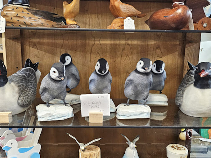 A parliament of penguin figurines stands at attention, silently judging your decision not to adopt the whole family for your mantel.